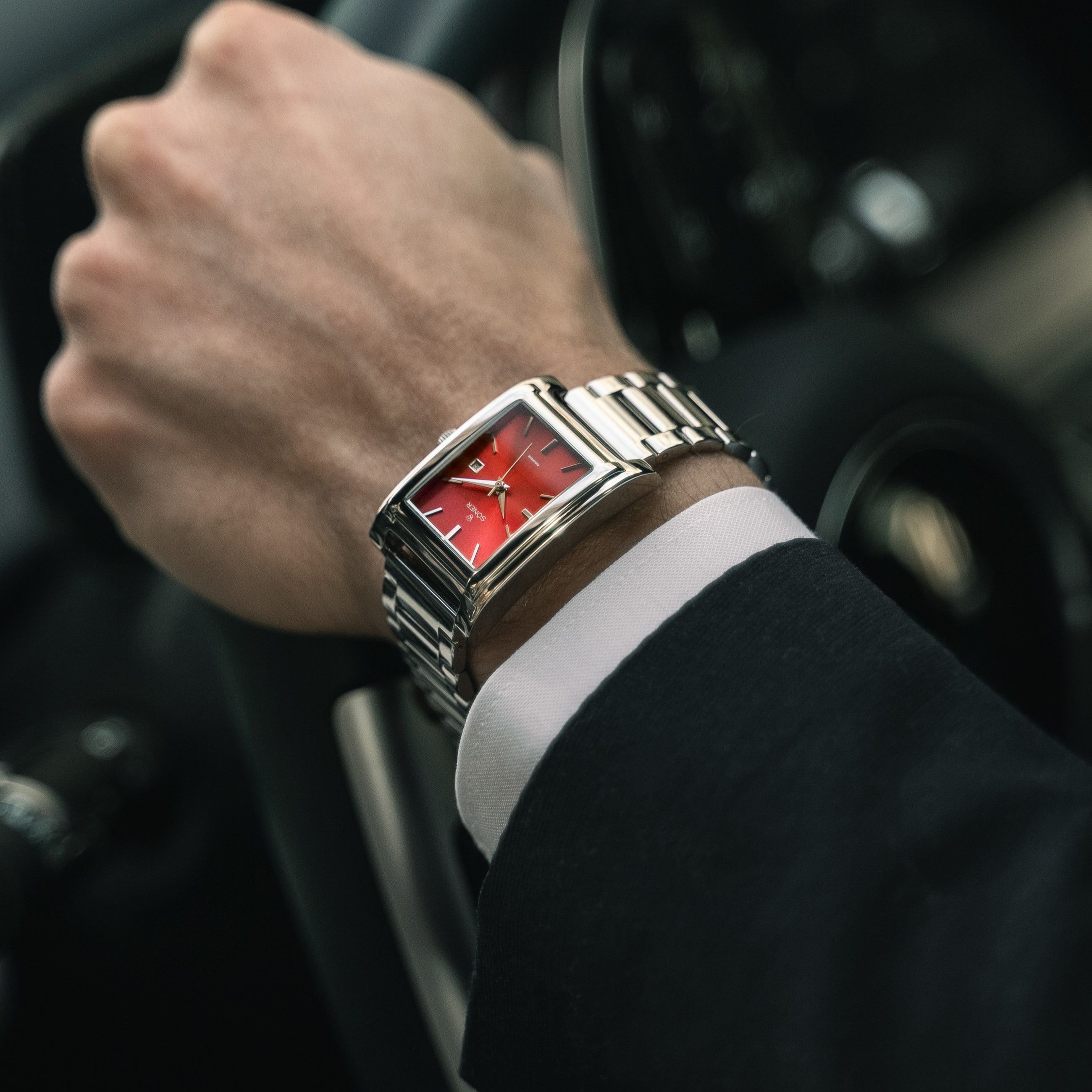 Rio, a rectangular watch in polished steel with red dial